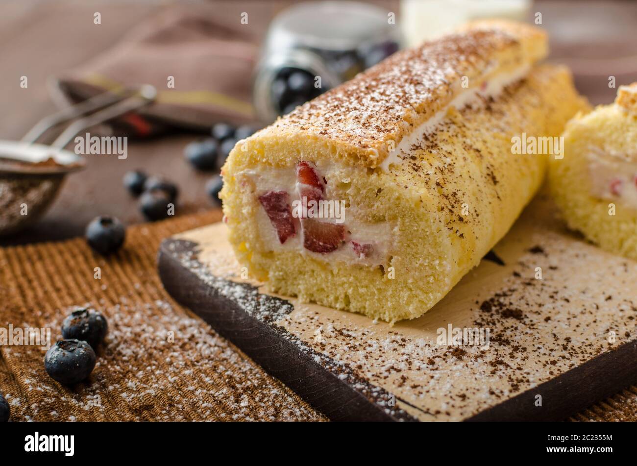 Sponge roll stuffed with strawberry cream Stock Photo - Alamy