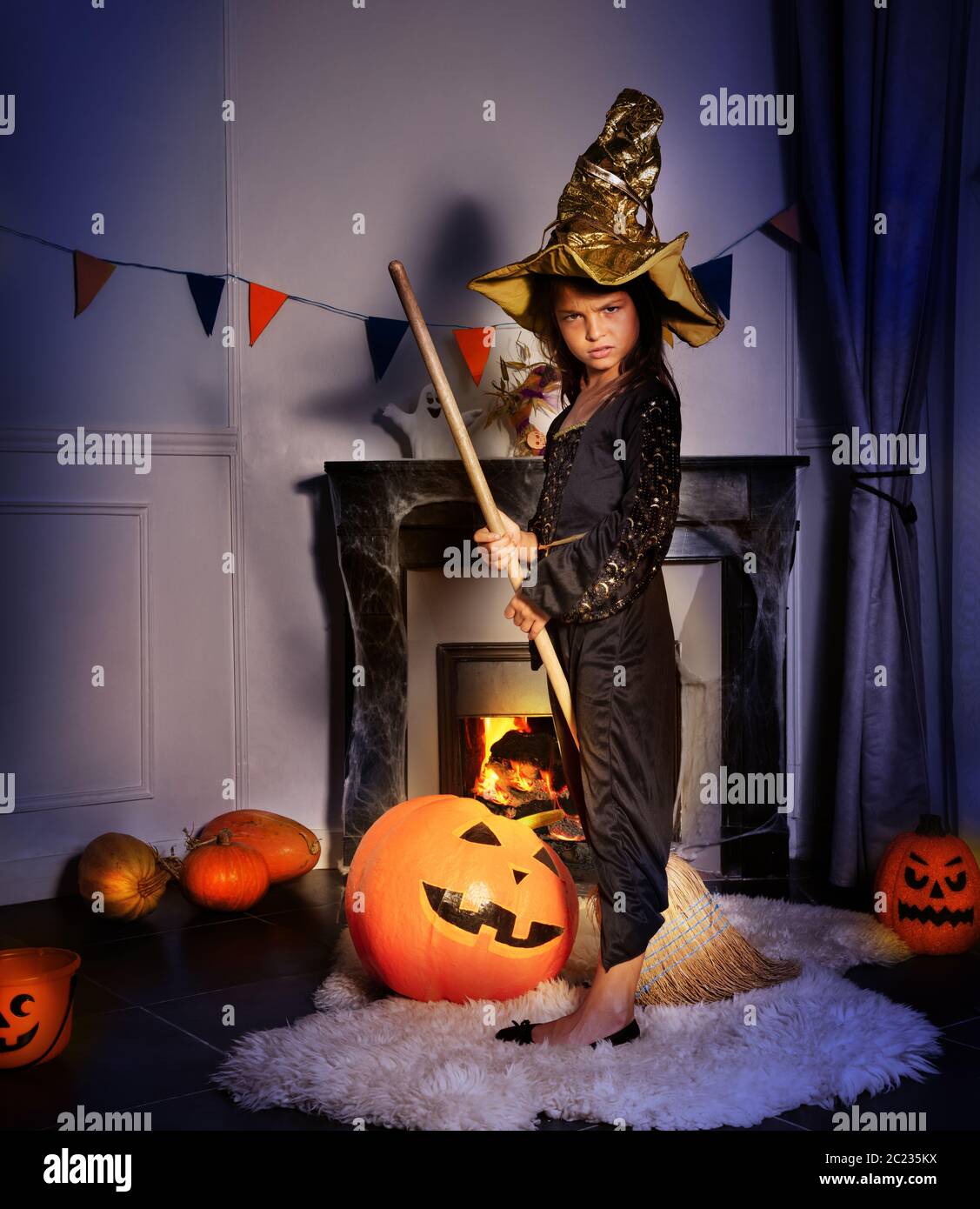 Portrait of a girl play grumpy witch in Halloween costume stand by ...
