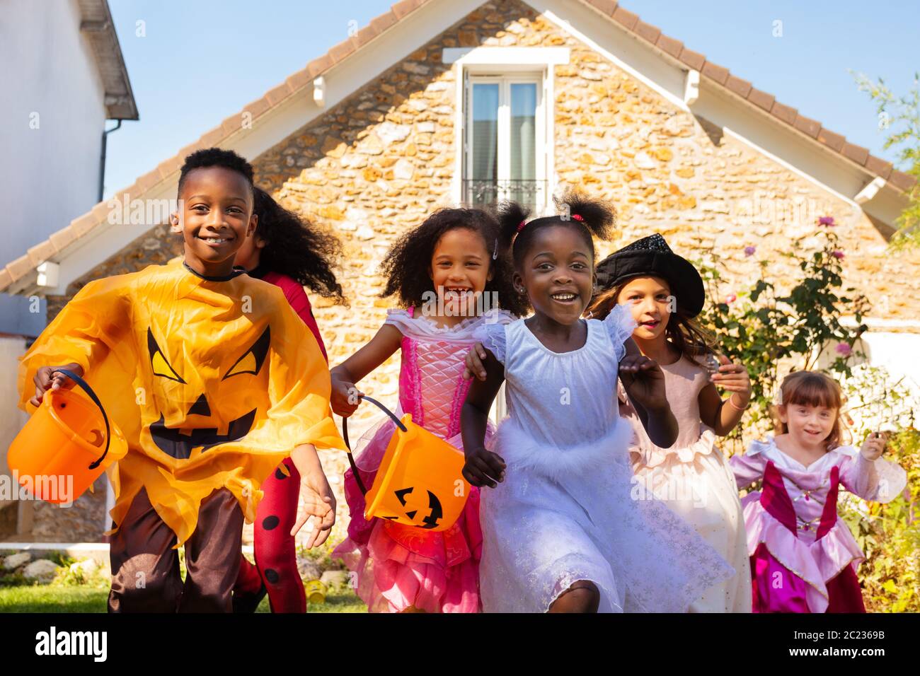 Close portrait of a group of children run in Halloween costume on the ...