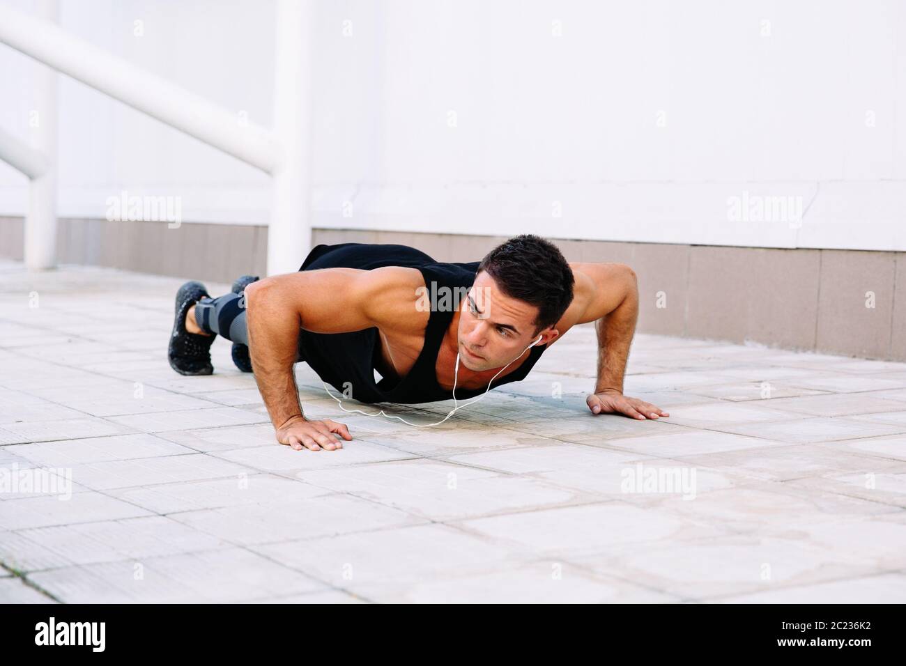 Attractive muscular guy doing push-ups exercises, during workout ...