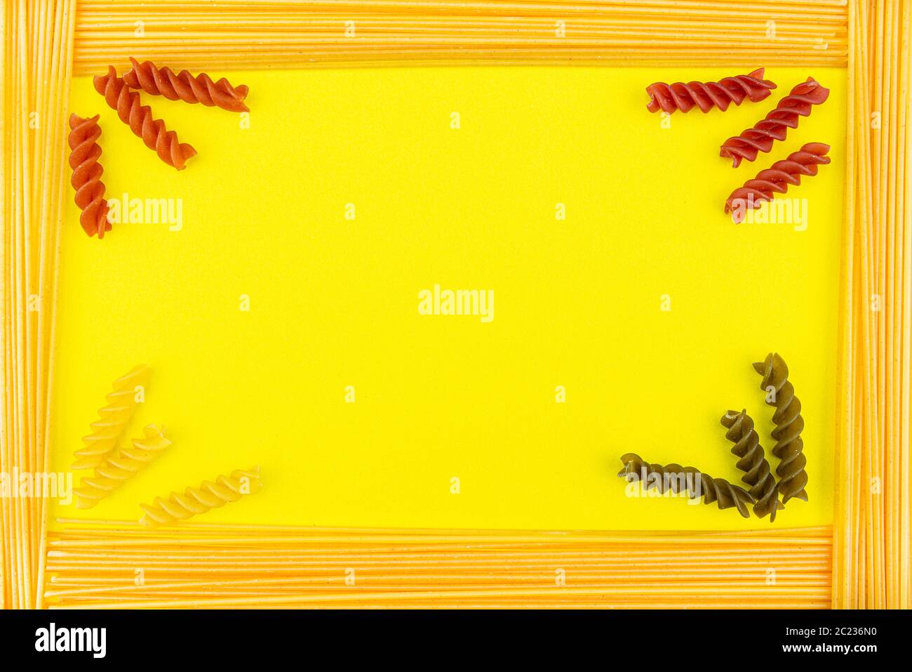 Frame made of spaghetti pasta on a yellow foam background, colorful ...