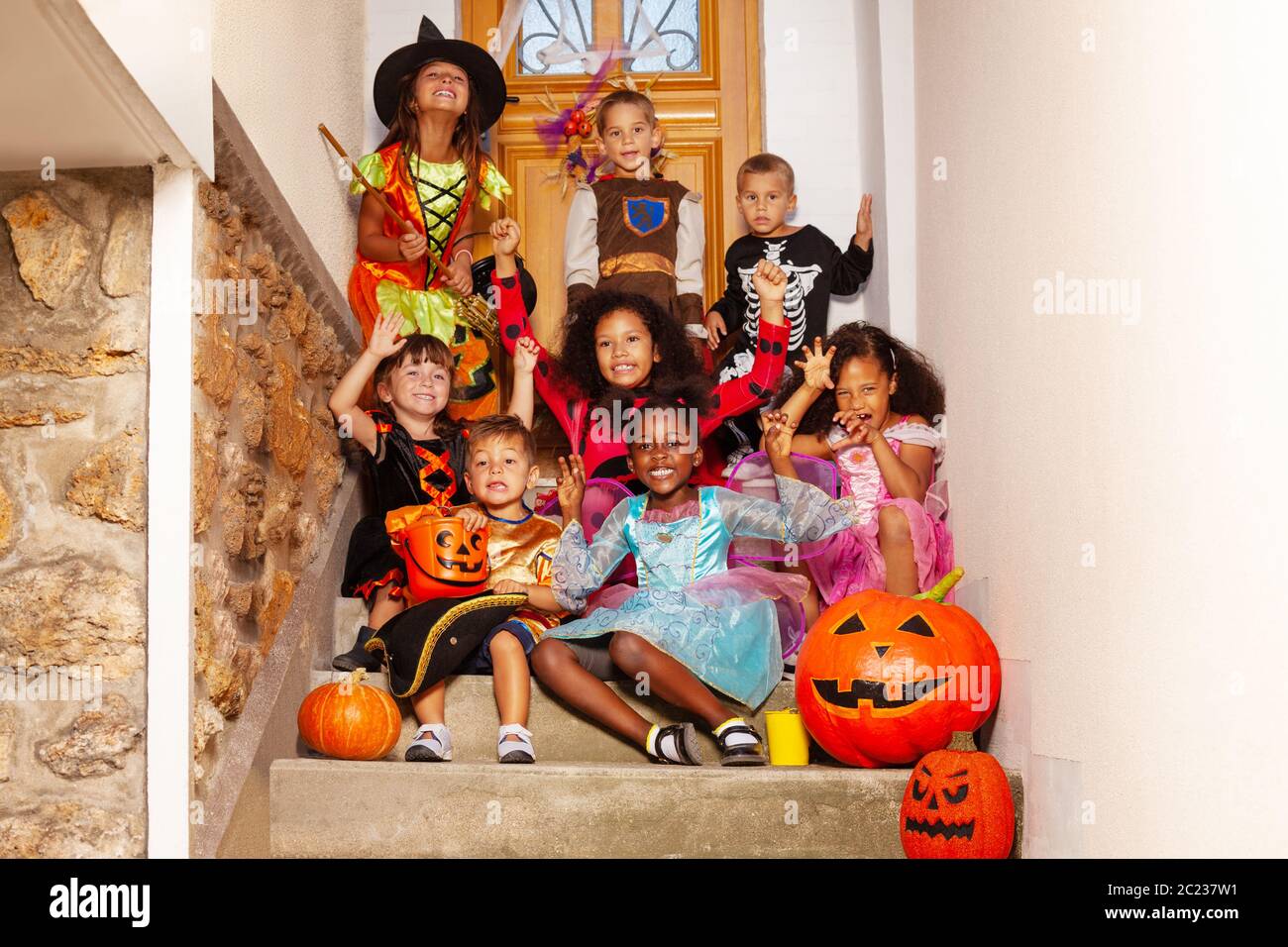 Halloween group kids with spooky gestures sit together boys, girls on ...