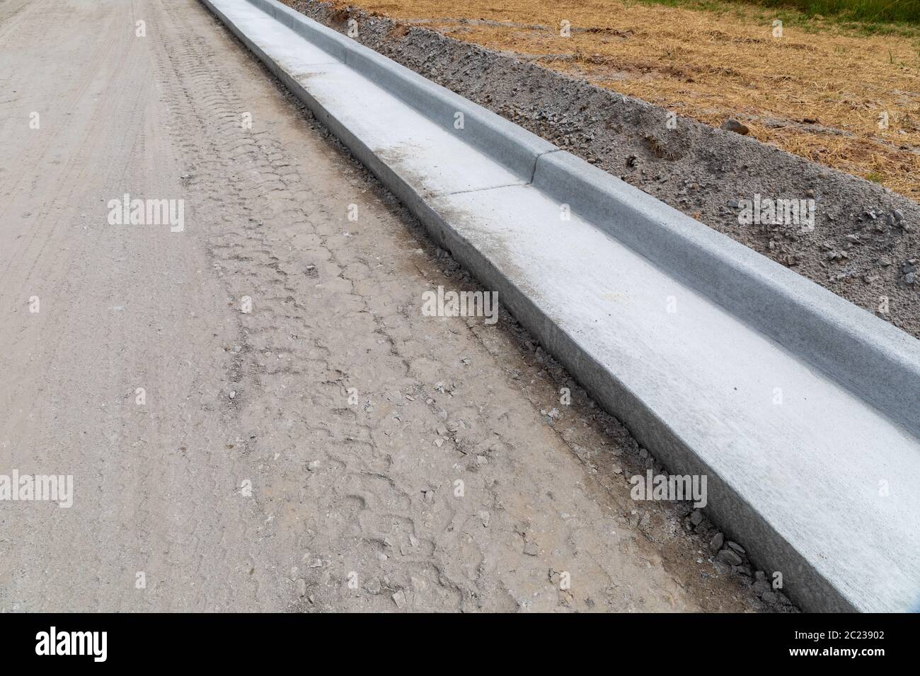 New road under construction, dirt roadway edged with freshly formed ...