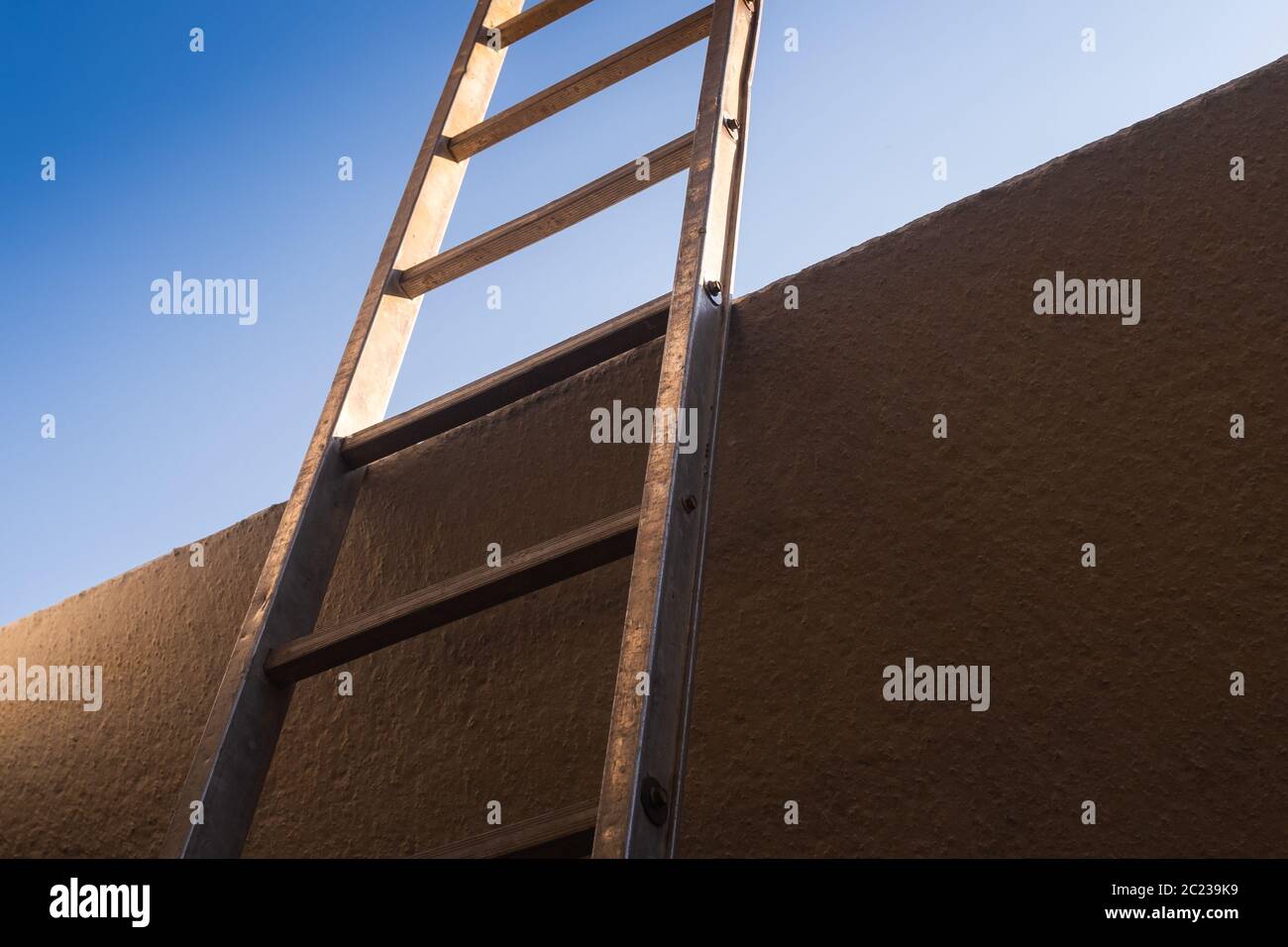 Low angle view of metal ladder leaning against concrete wall, the ...