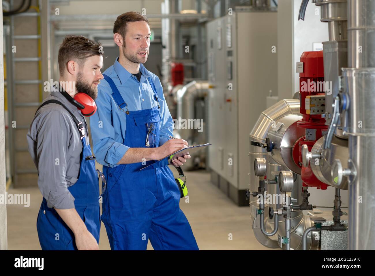 two worker in blue work clothes in industrial plant Stock Photo - Alamy