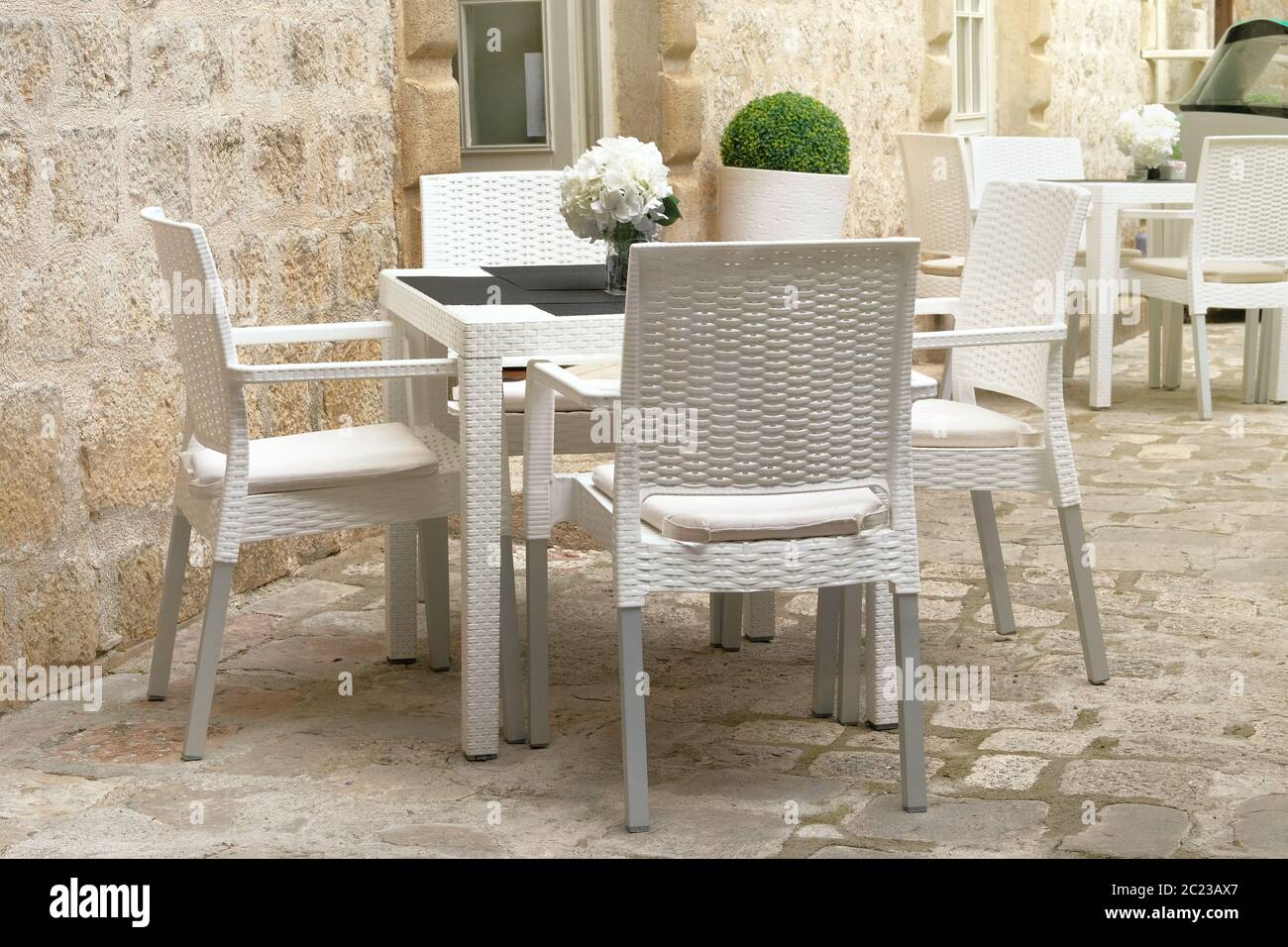 Empty patio in summer in recreation. White table and armchairs on ...