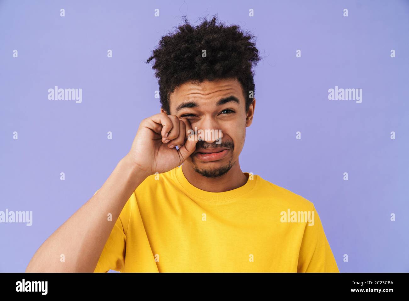Photo of unhappy african american man crying and looking at camera ...