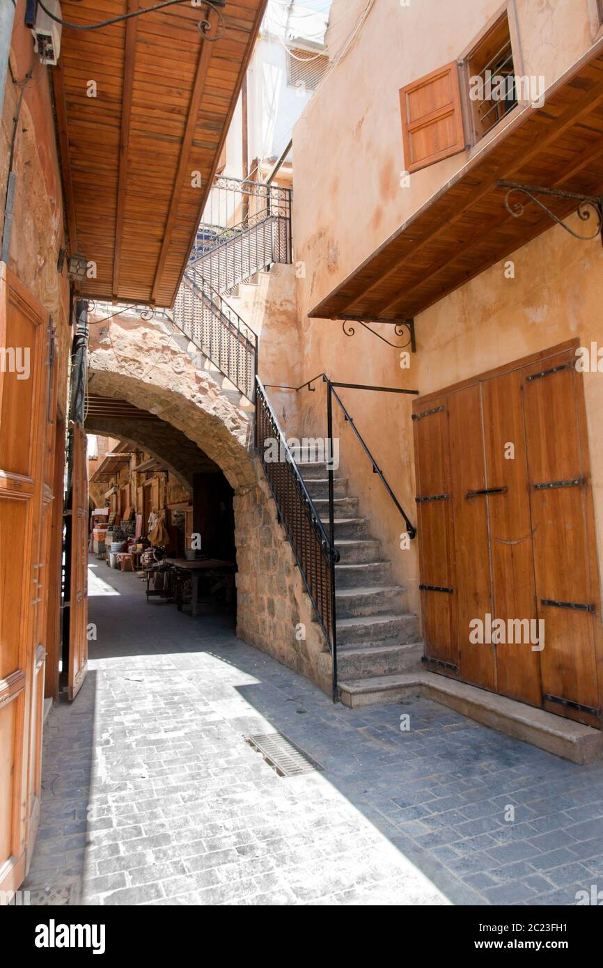 Old street with sandstone arc and wooden closed doors in downtown of ...