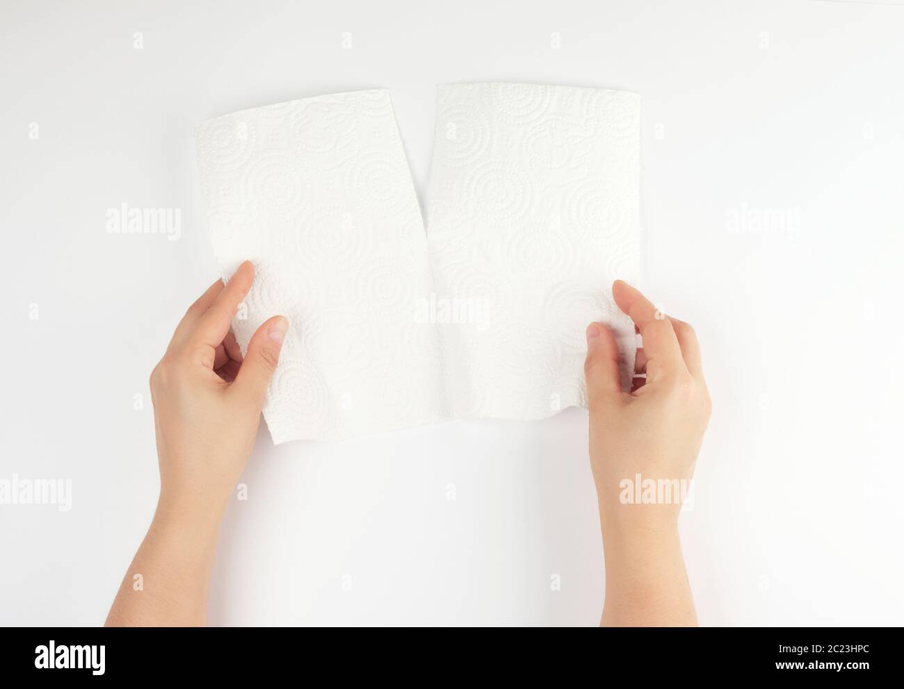 two female hands holding a clean white paper napkin for face and body ...