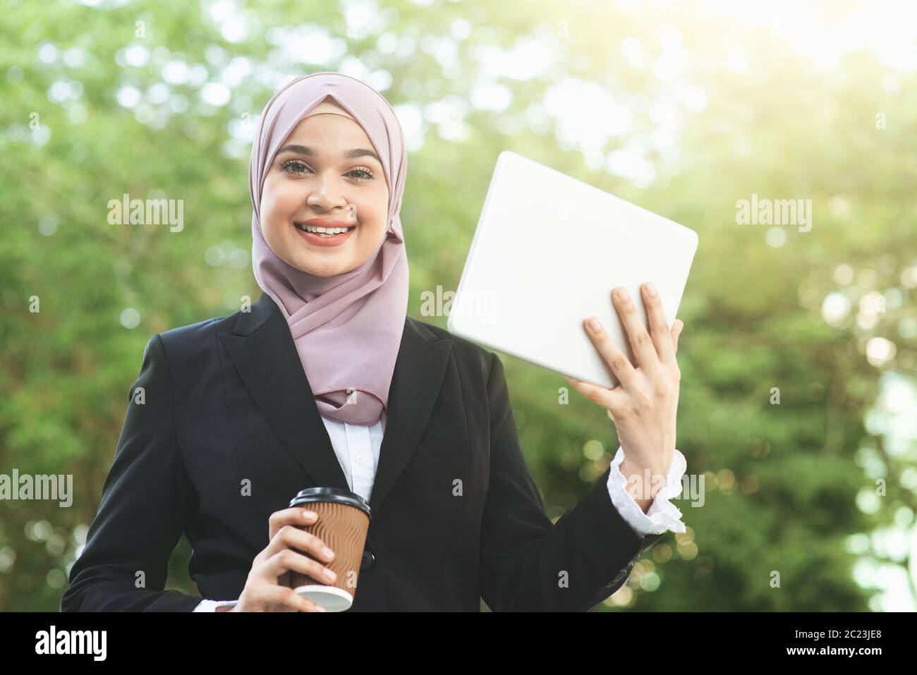 Muslim business woman drinking coffee while going to work in morning ...