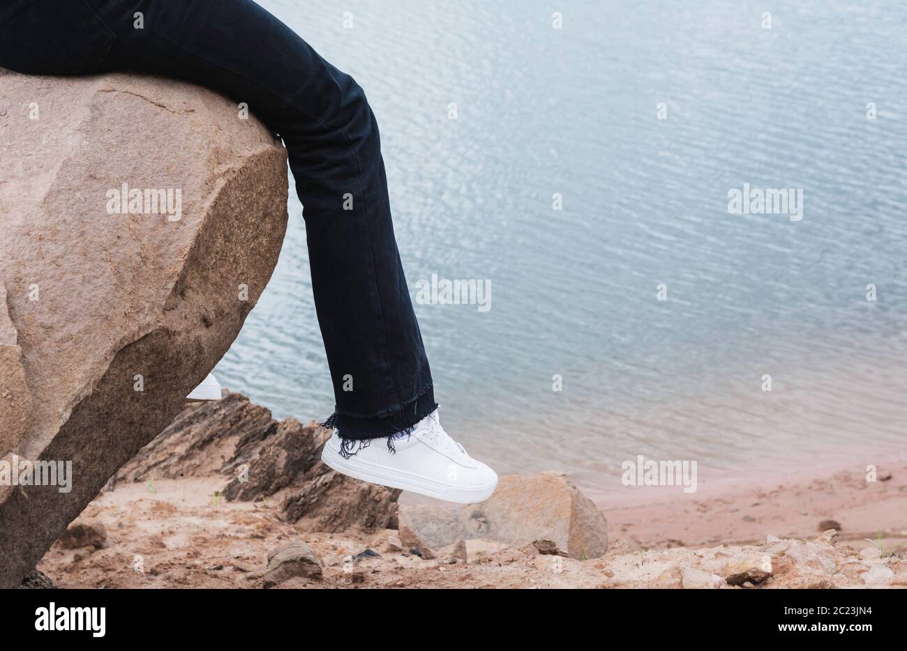 Girl resting on a rock. Woman sitting on rock near river Stock Photo ...