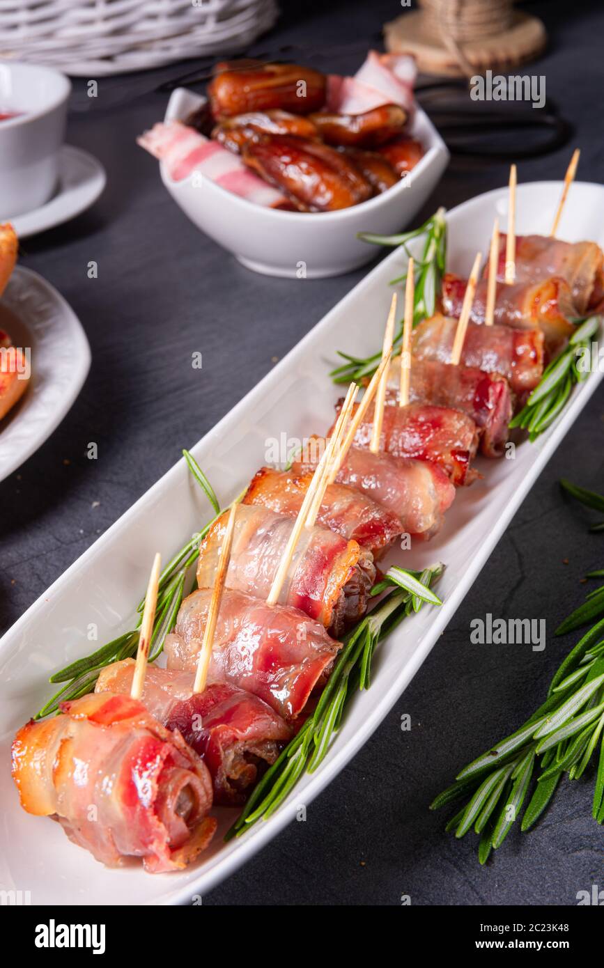 dates wrapped in bacon and delicious tapas Stock Photo - Alamy