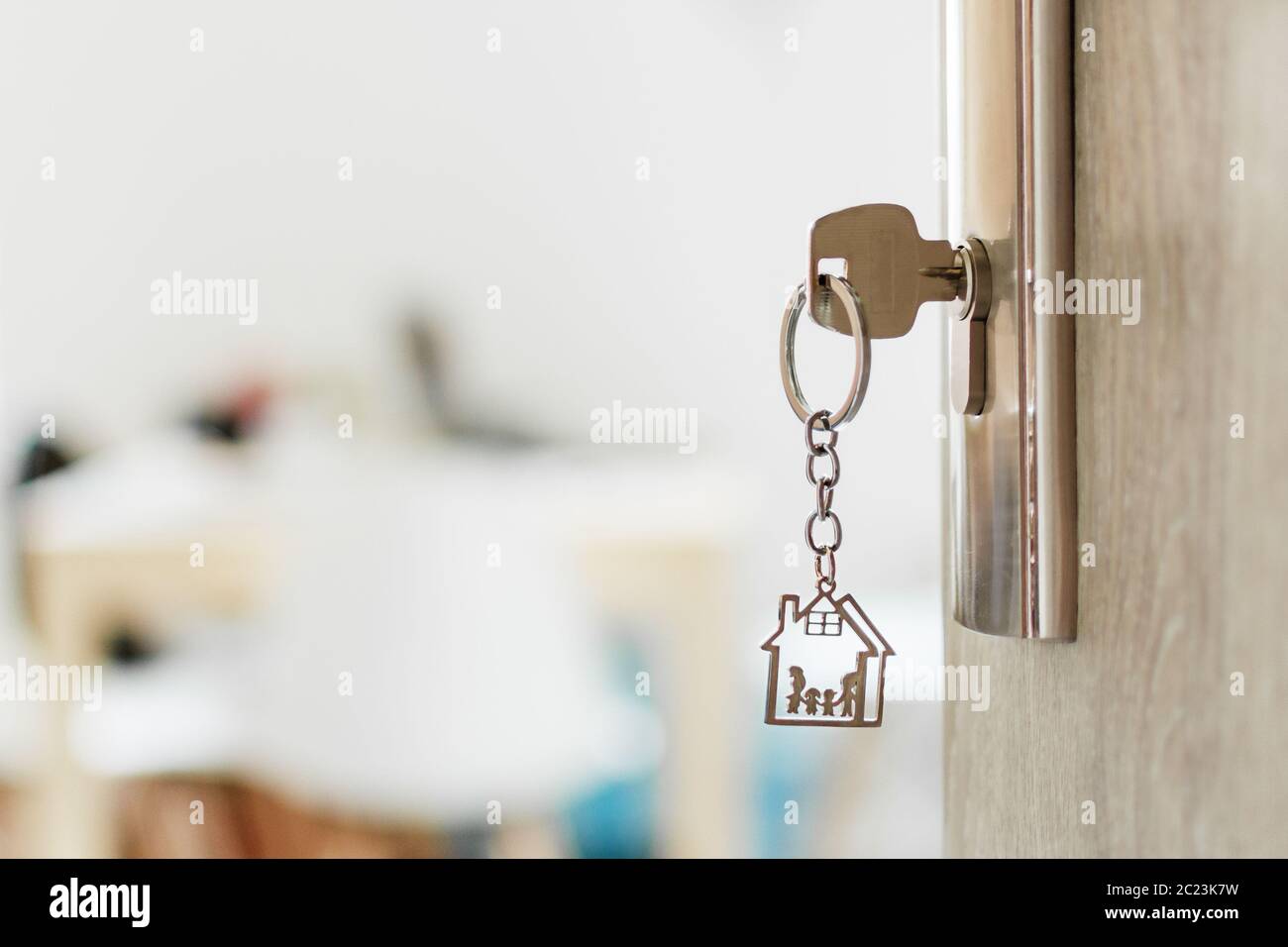Key with keychain in a house shape and family in the door keyhole. Buy ...