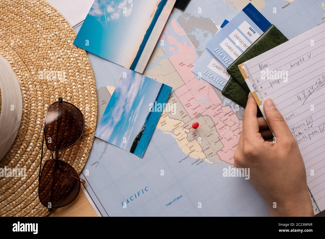 Close-up of unrecognizable tourist checking notes before travel, straw ...