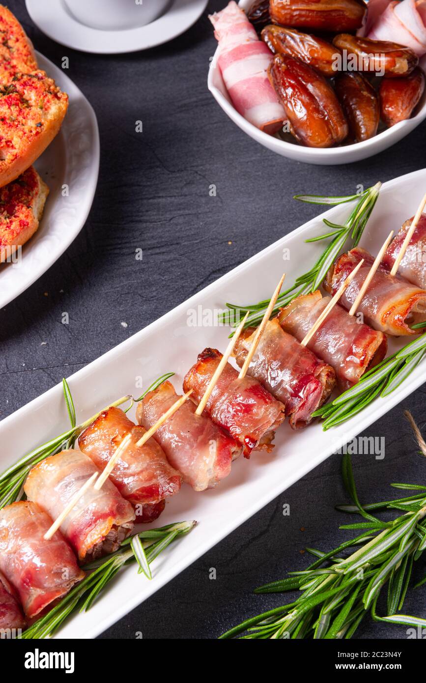 dates wrapped in bacon and delicious tapas Stock Photo - Alamy