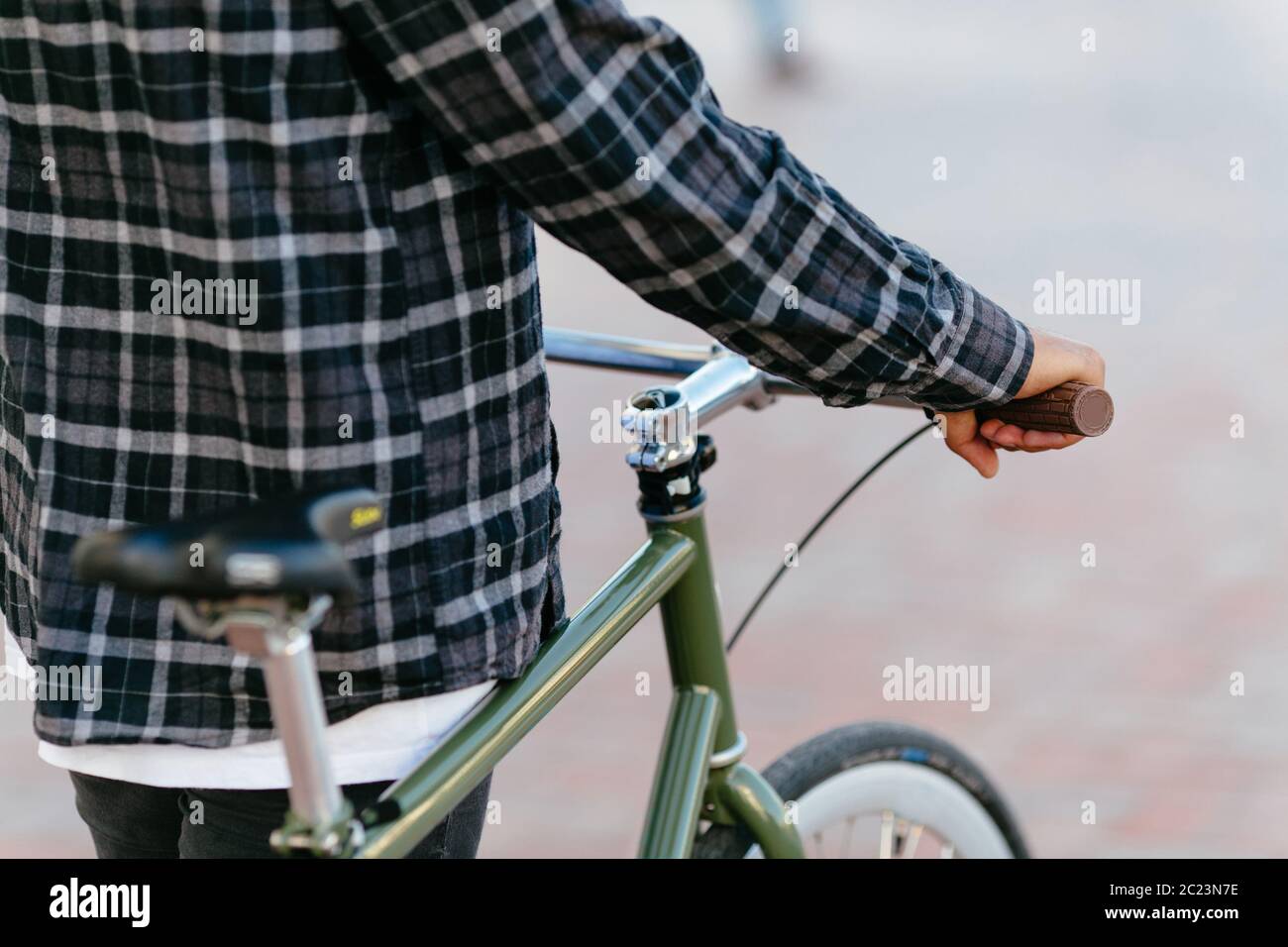 Back view on stylish man standing with bicycle outdoors. Close-up Stock ...