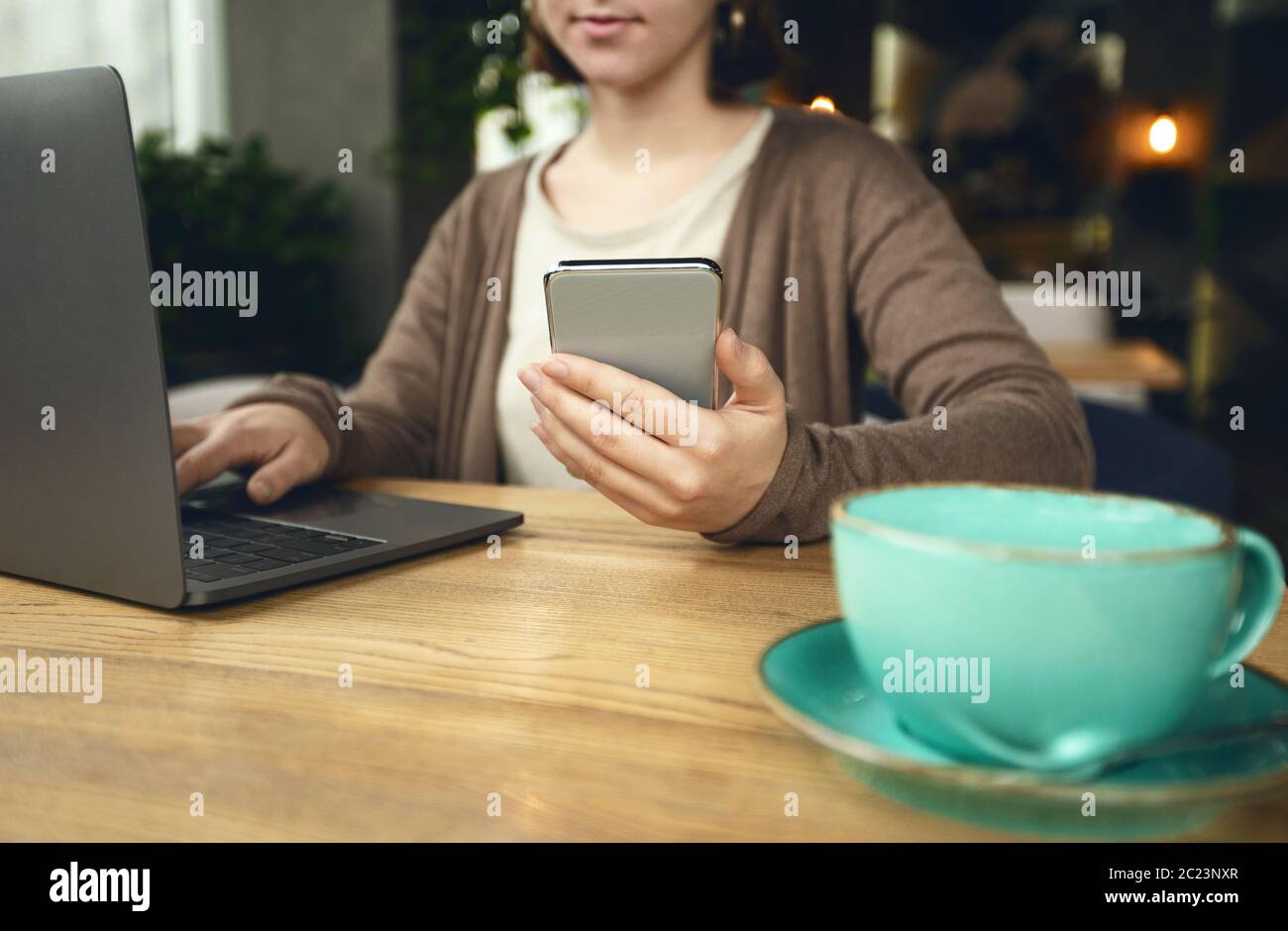 Young woman giving information from cell phone on laptop Stock Photo ...