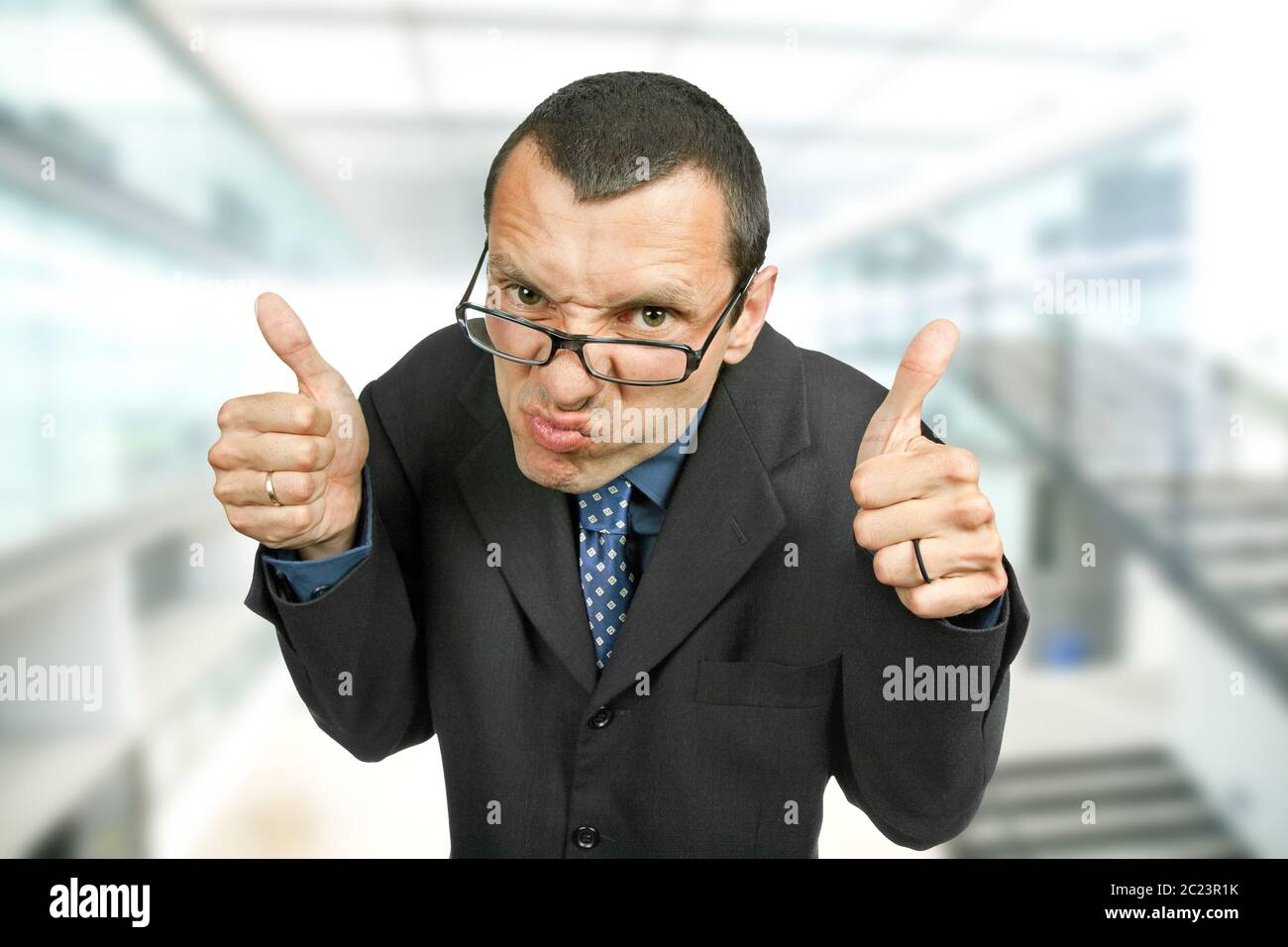 young silly business man going thumbs up Stock Photo - Alamy