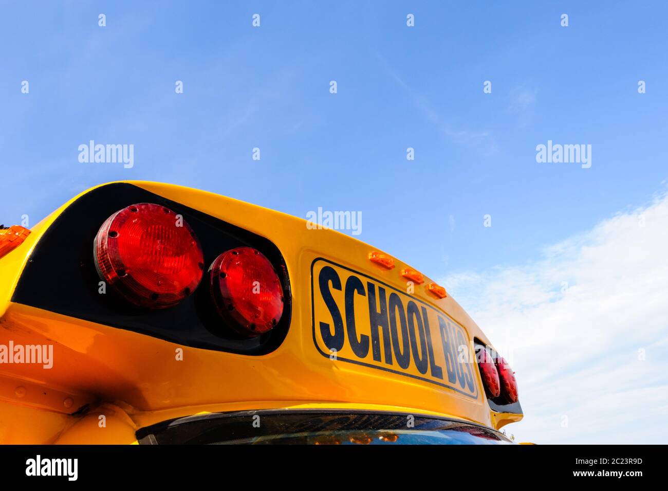 Upper front of yellow school bus lights and sign against empty sky ...