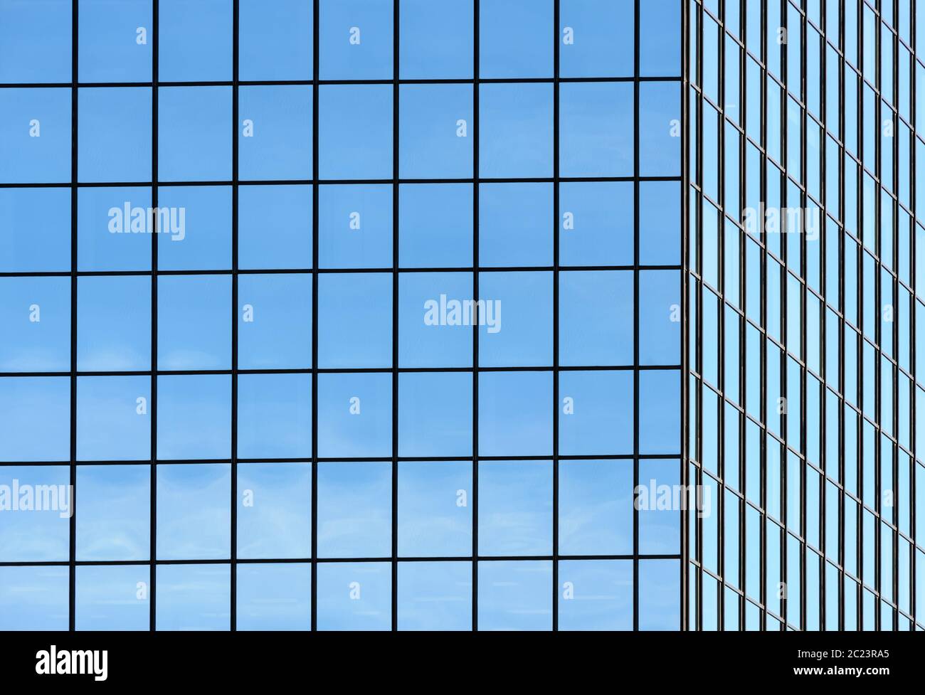 Corner of office building windows in square grid pattern reflecting sky ...