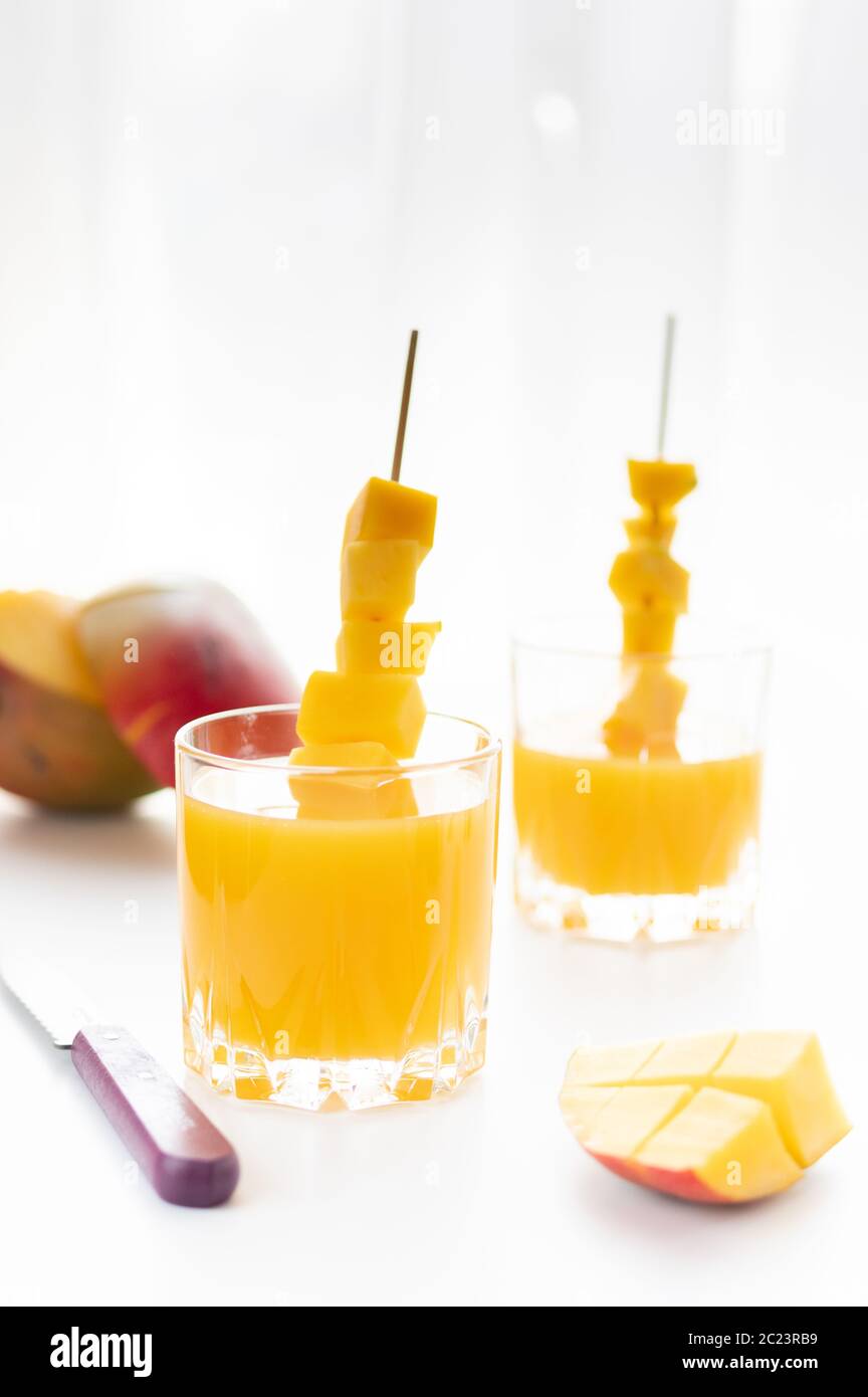 Fresh sliced mango and mango juice. Mango juice in two glasses ...