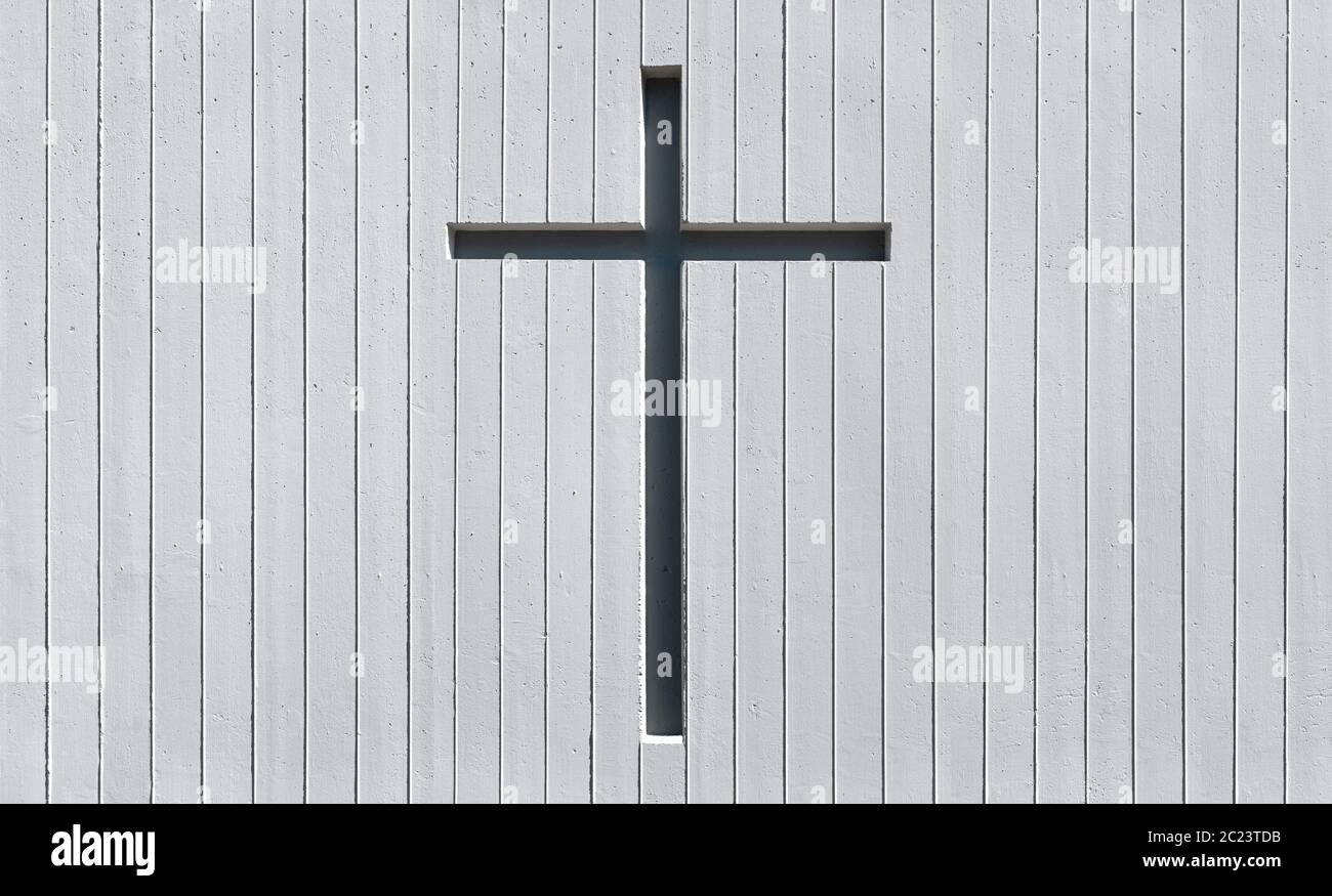 Cross in a white wall made of exposed concrete with vertical stripe ...