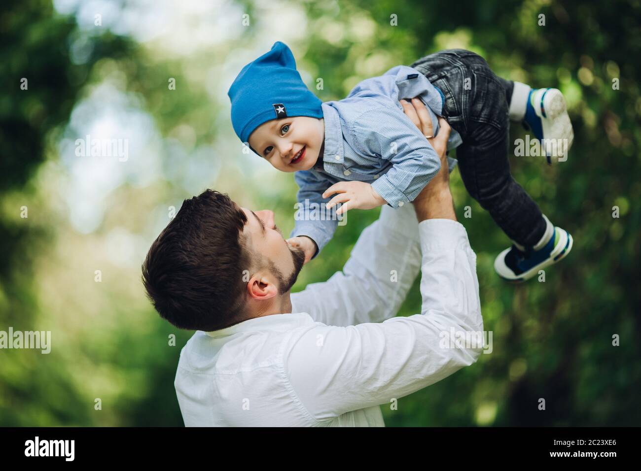 Handsome father throwing baby boy against summer park Stock Photo - Alamy