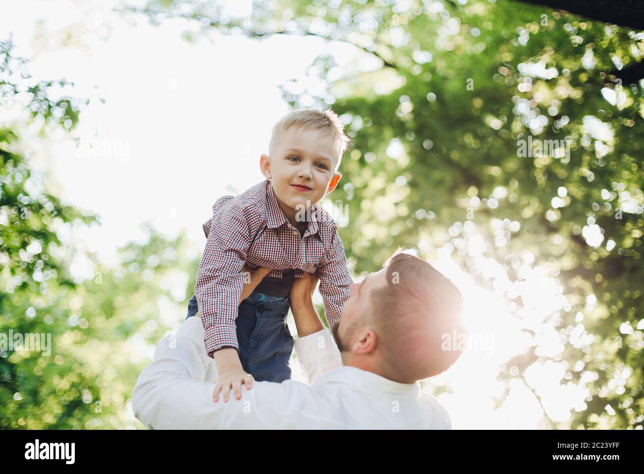 Handsome father throwing baby boy against summer park Stock Photo - Alamy