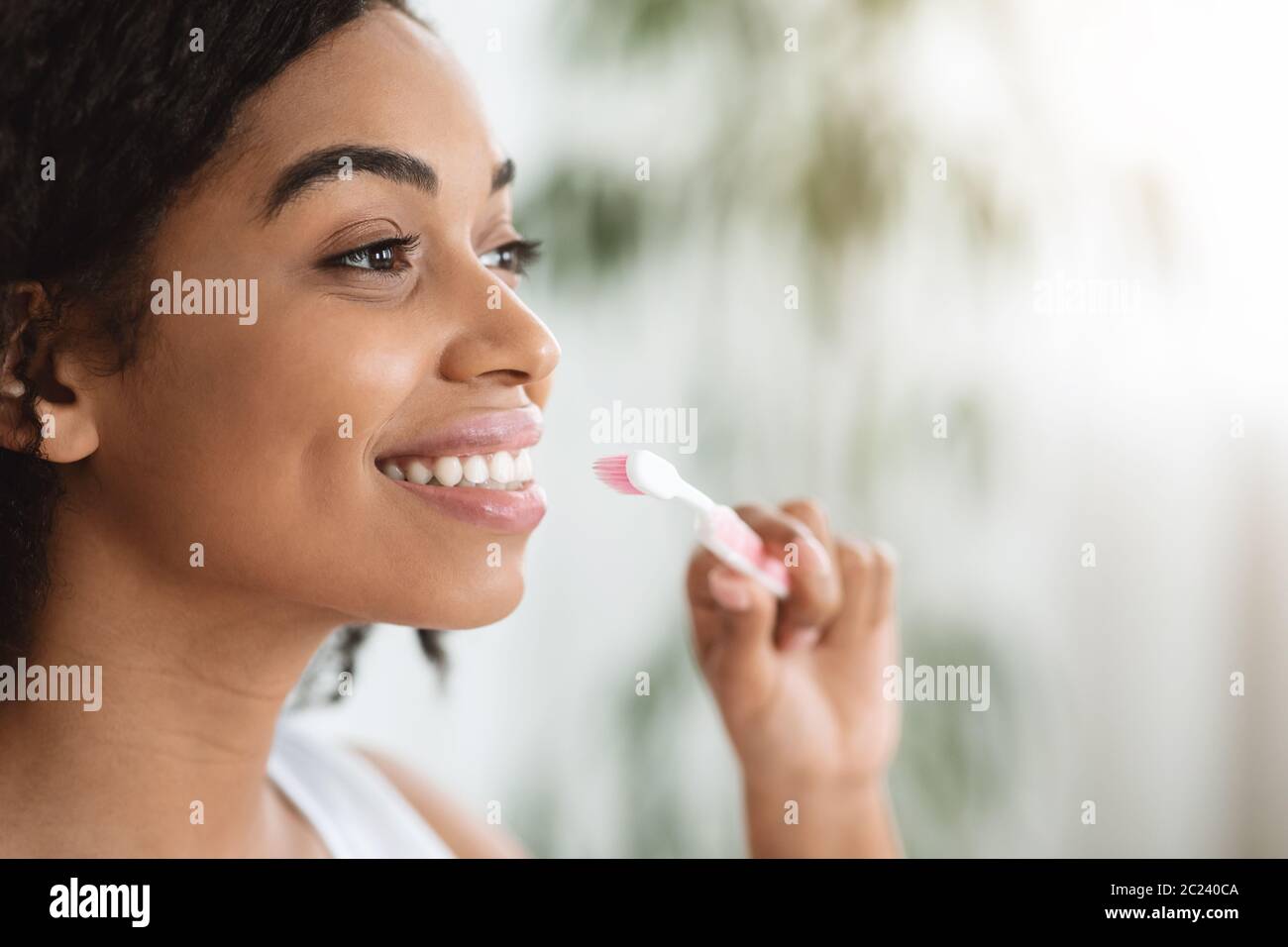 Dental health. Happy black woman holding toothbrush, ready for brushing ...