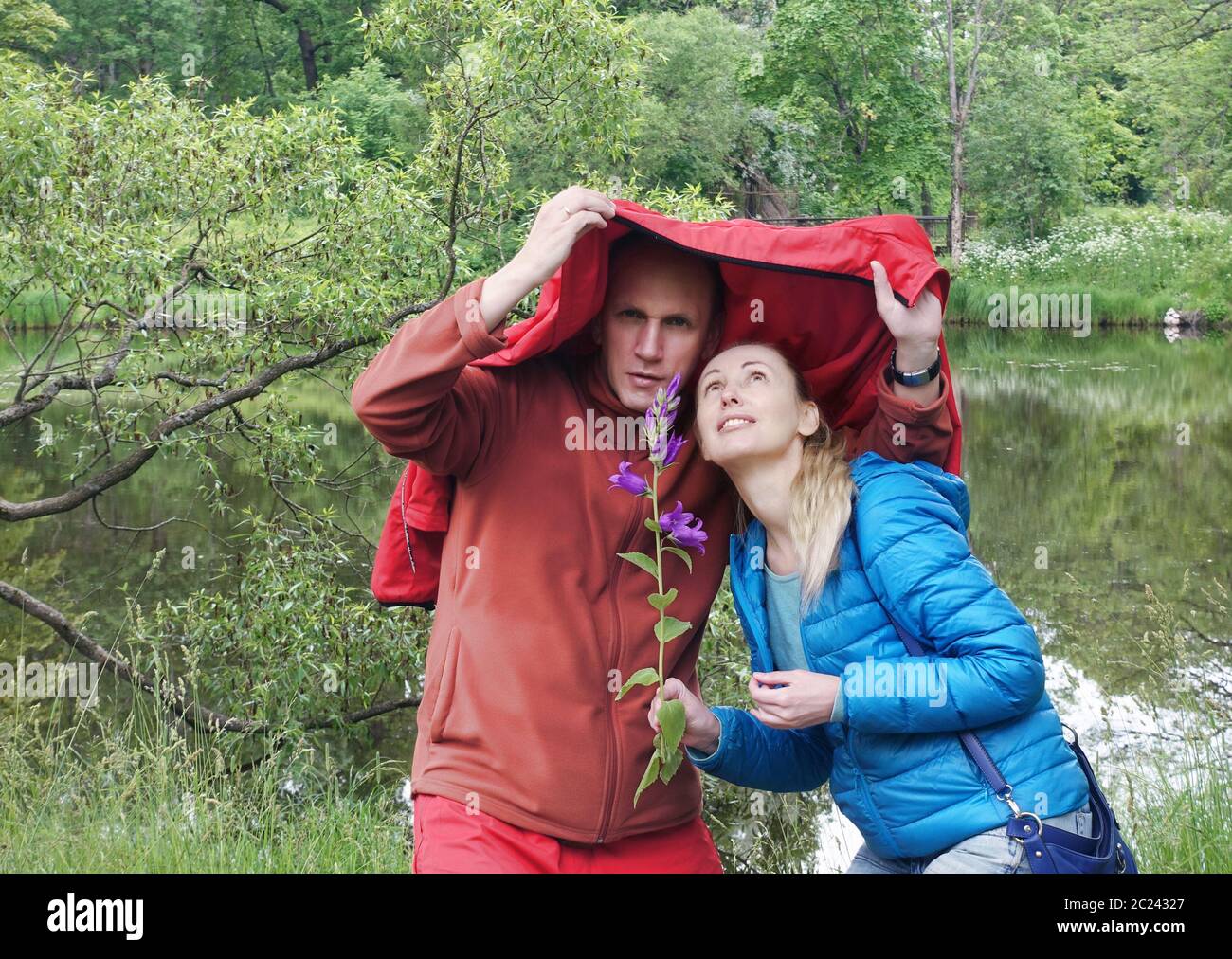 man and woman hiding from the rain on the lake Stock Photo - Alamy