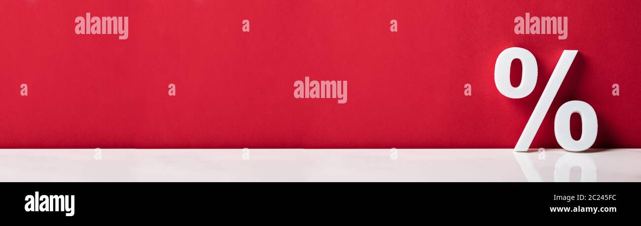 White Percent Sign In Front Of Red Wall Stock Photo - Alamy