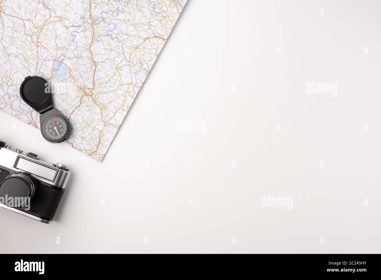 top view travel concept with retro camera, map and compass on white ...