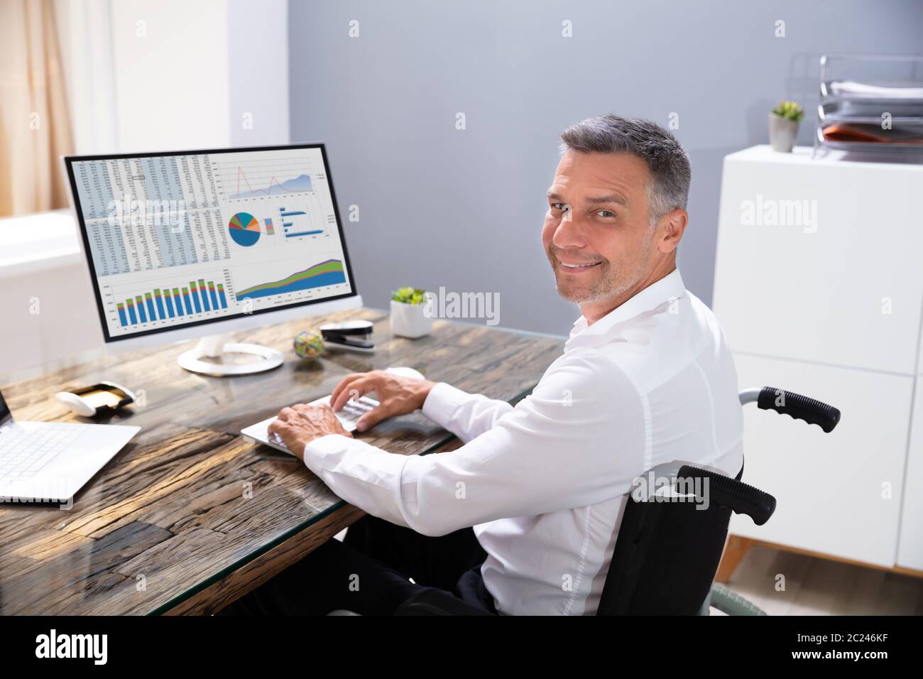 Handicapped Businessman Sitting On Wheelchair And Using Computer In ...