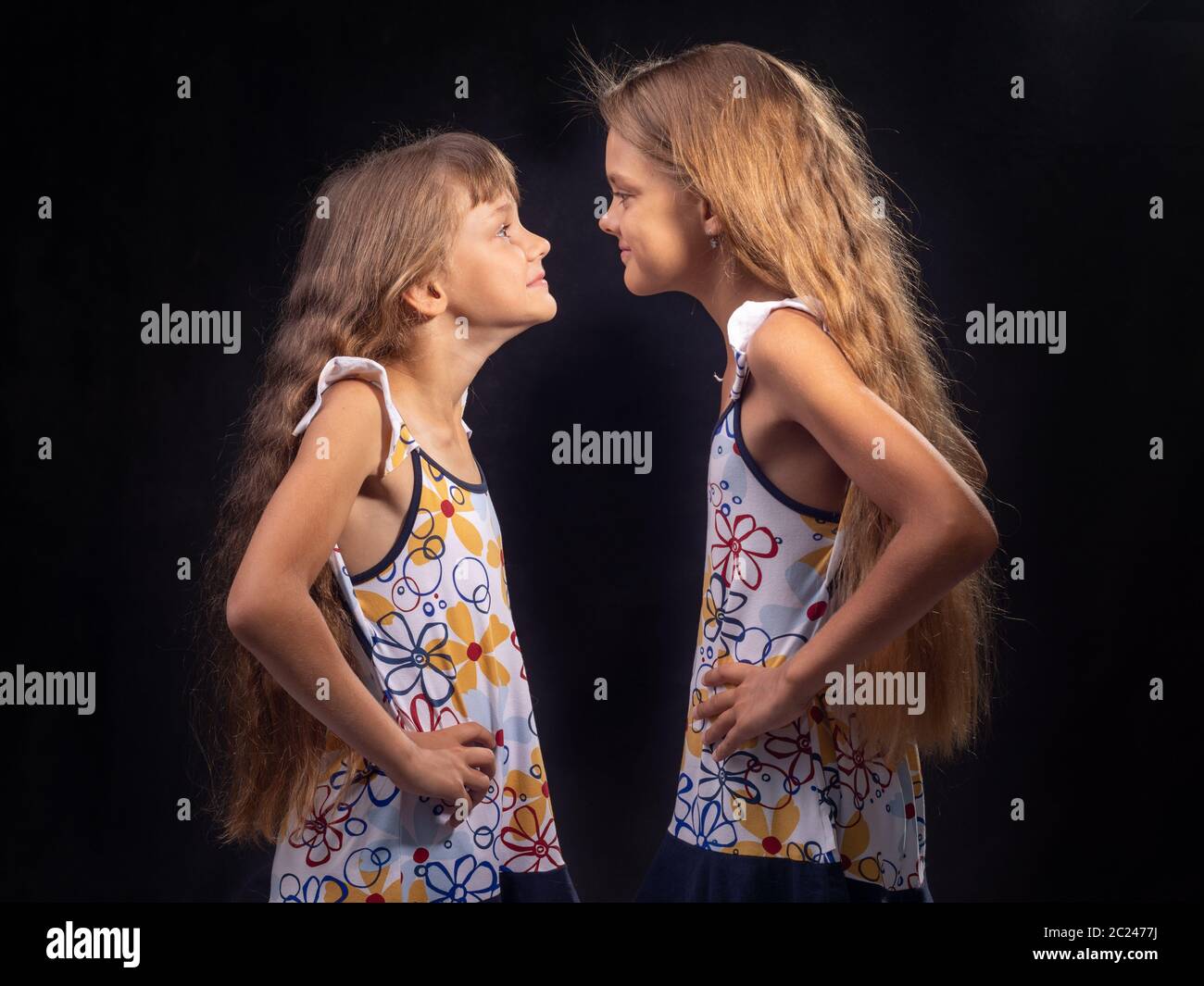 Two girls are standing opposite each other and putting their hands on ...