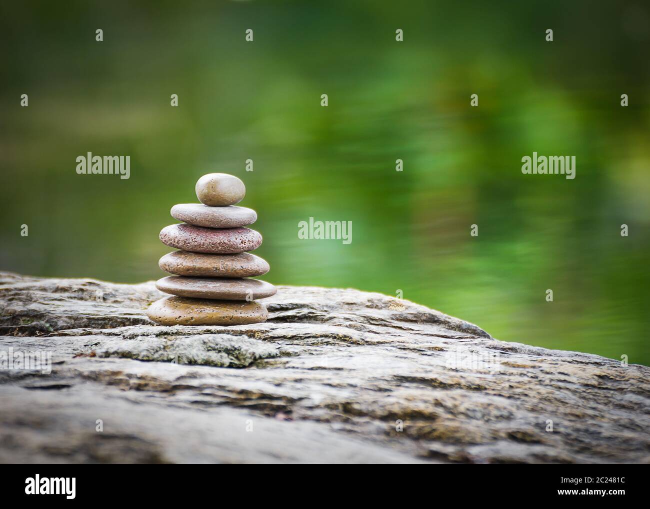 Conceptual,Stack of zen rocks in garden on green background Stock Photo ...