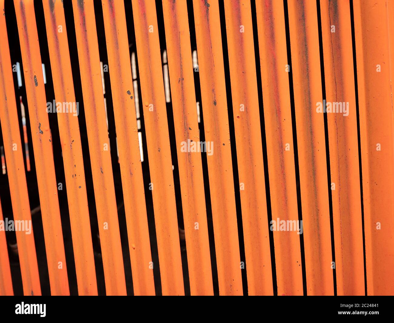 Rust speckled dark orange painted vertical metal slats Stock Photo - Alamy