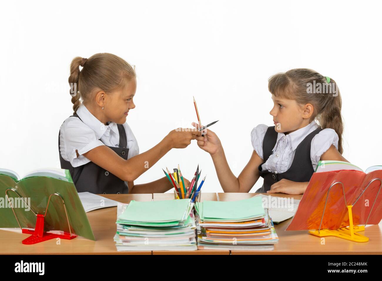 Two girls fight with pencils at a school desk Stock Photo - Alamy