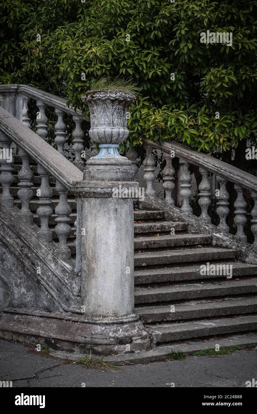 Ancient staircase with stone balusters against the background of green ...