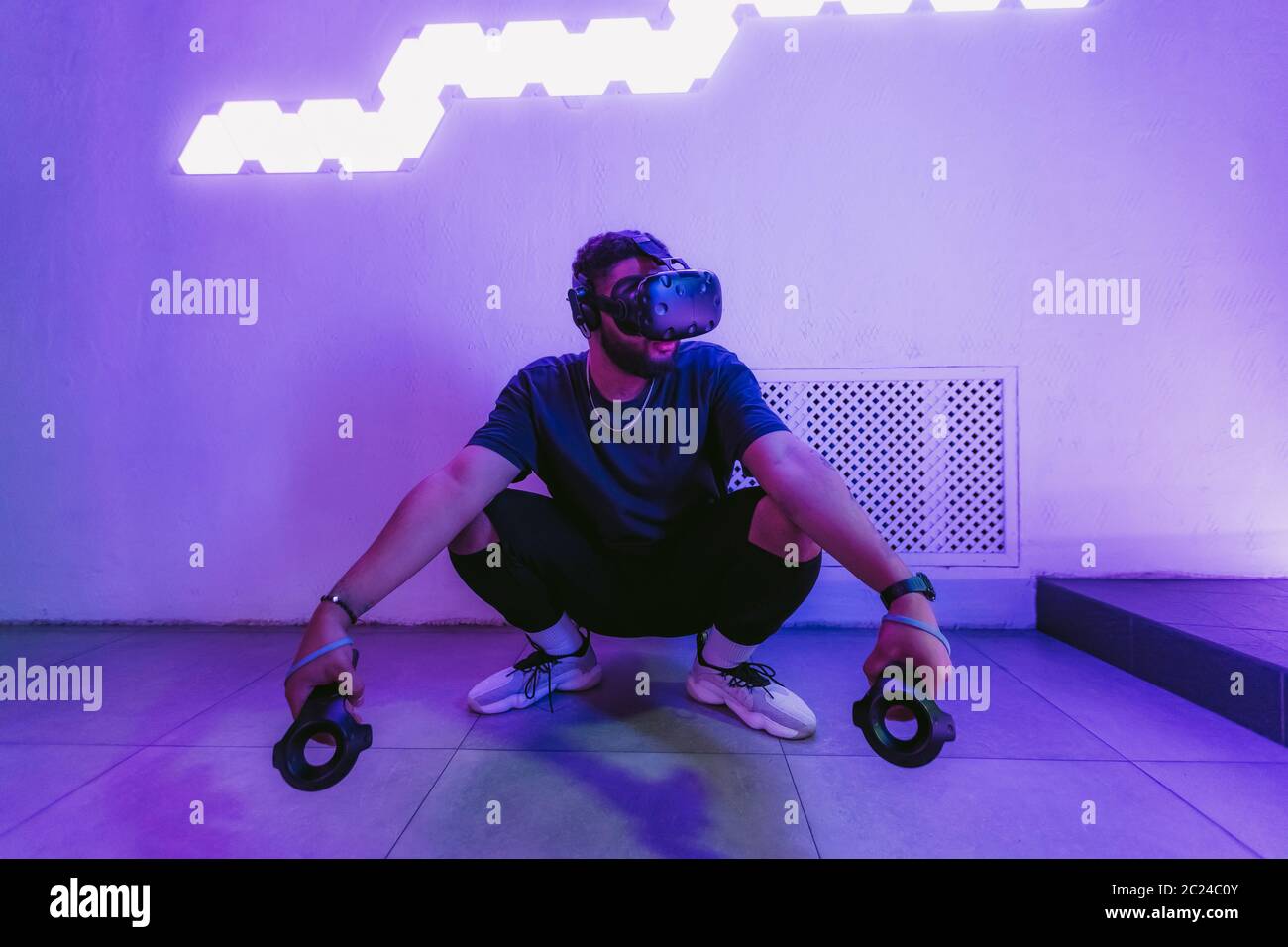 The guy is playing VR games. Neon blue light Stock Photo - Alamy