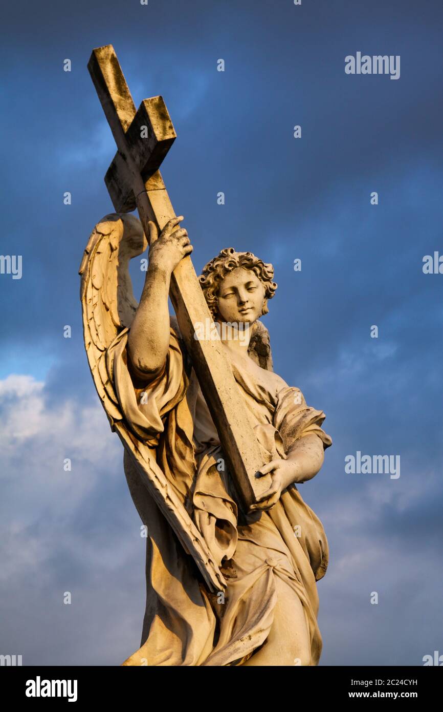 Figure of sad angel carries heavy cross in the evening light Stock ...