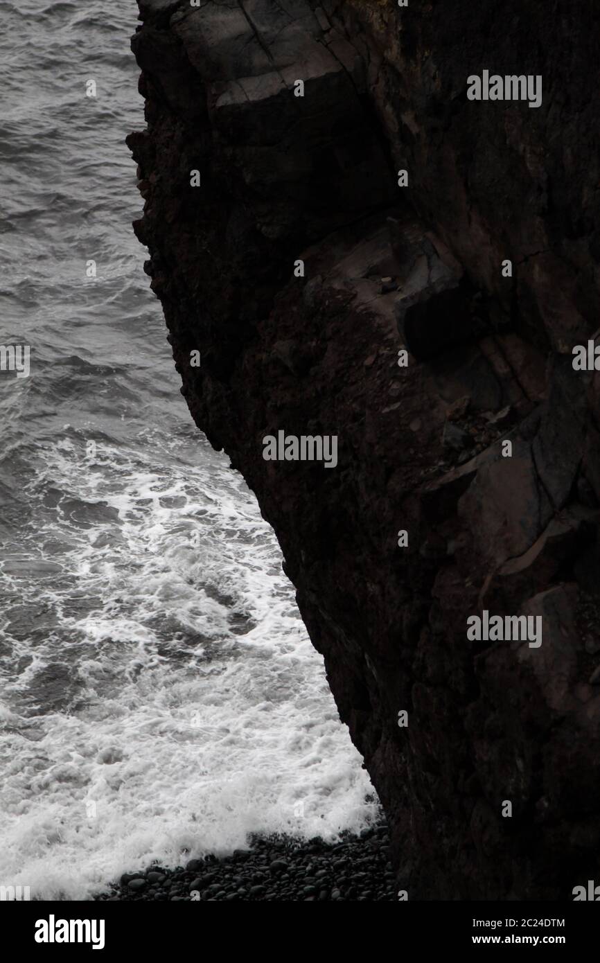 Rock edge with vertical view of surf Stock Photo - Alamy