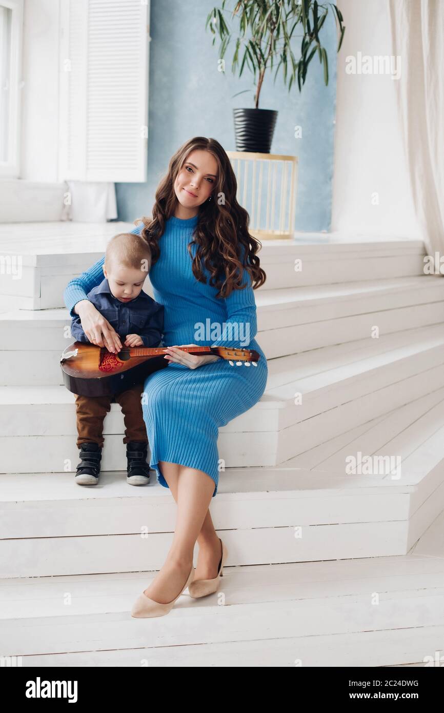 Loving beautiful mother playing music instrument with her son Stock ...