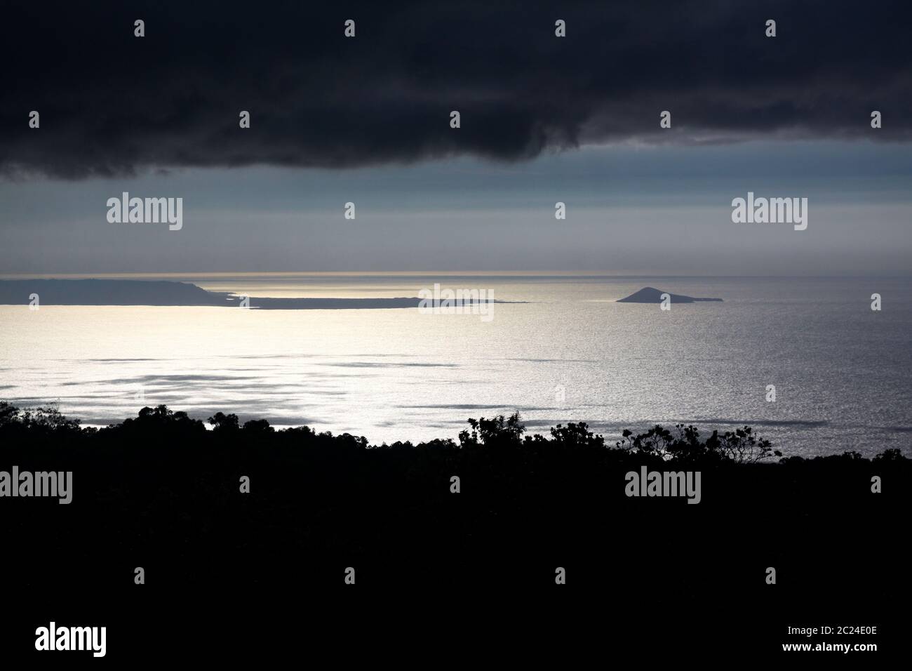 Gloomy mood with black clouds and view of illuminated sea Stock Photo ...
