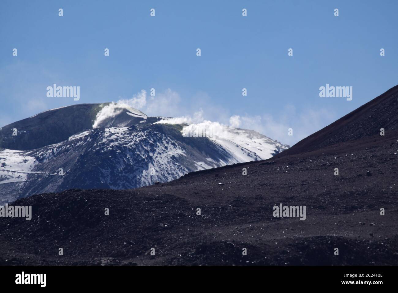 Peak of active volcano covered with smoke and snow Stock Photo - Alamy