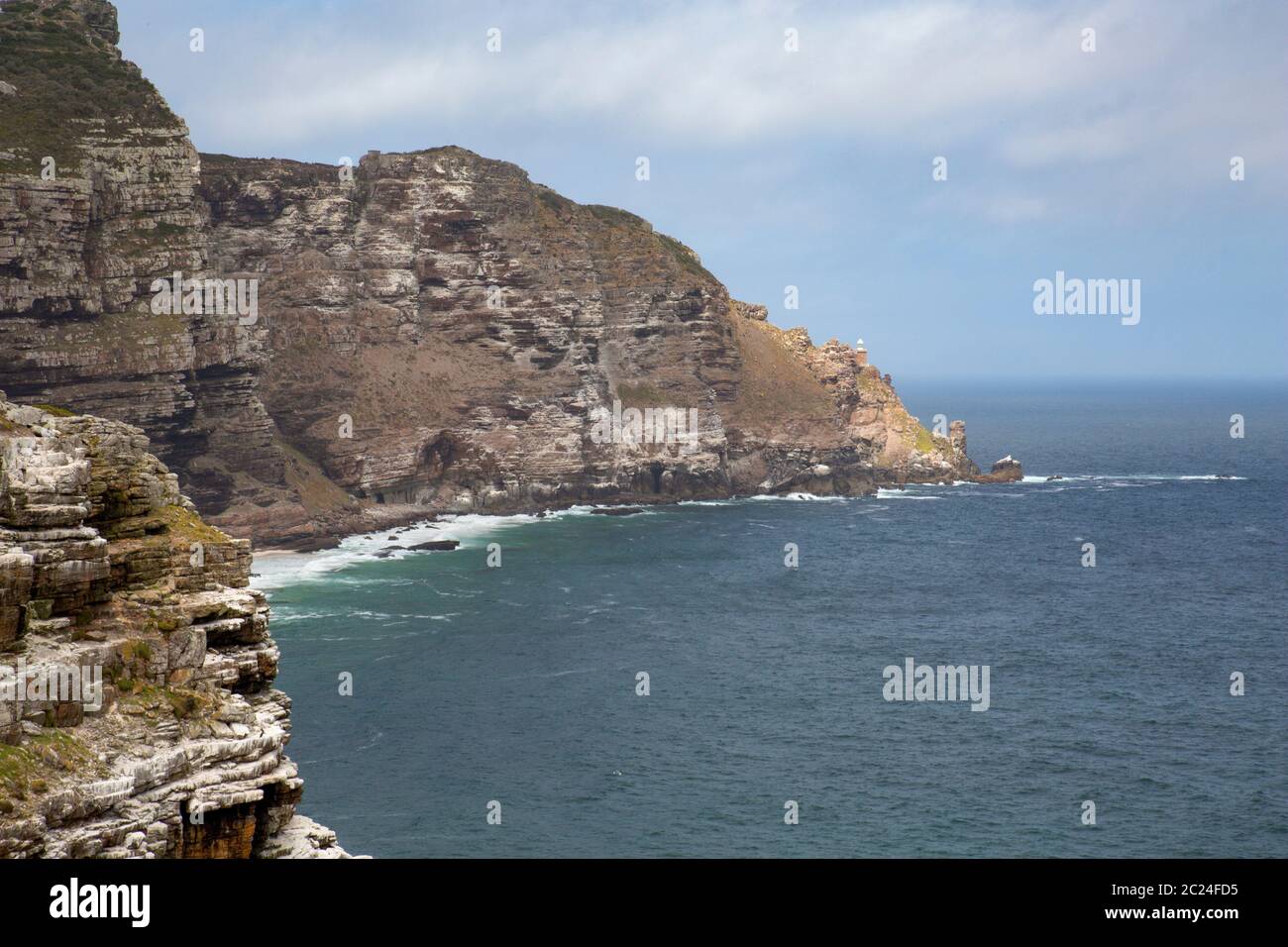 Bay with vertical sloping rocky coast into the blue sea Stock Photo - Alamy