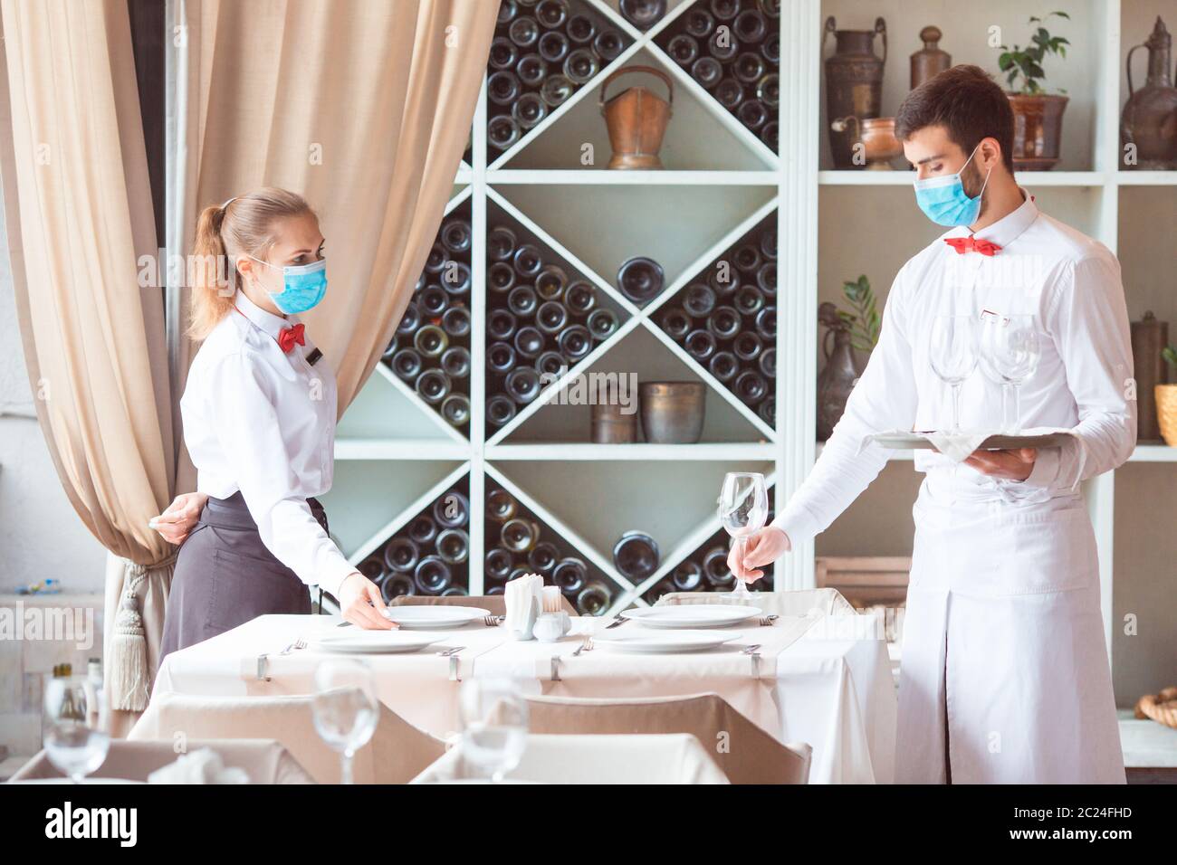 the waiter serves a table in a cafe in a protective mask Stock Photo ...