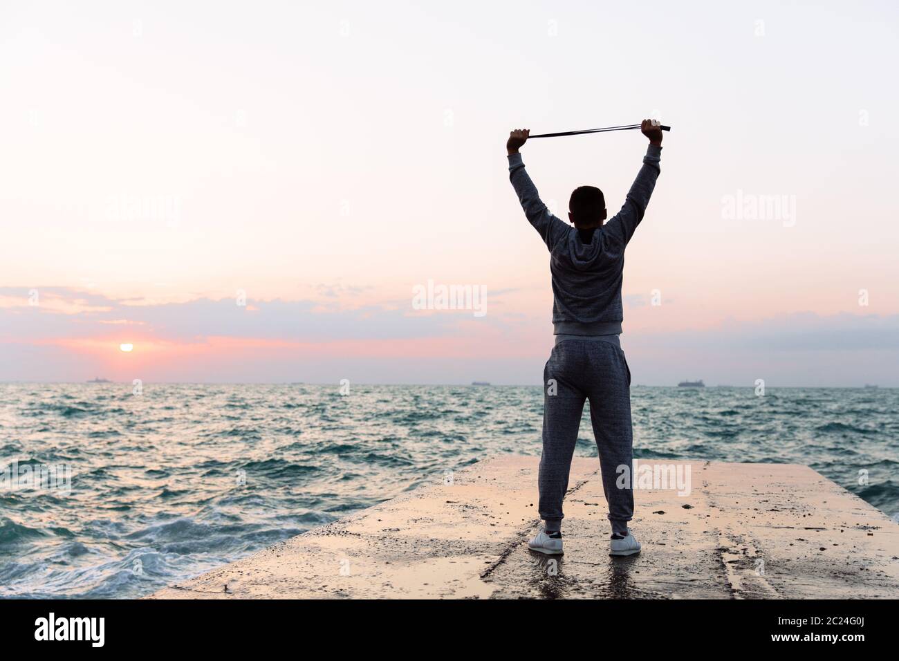 Full length photo of sportsman practicing exercises, stretching with ...