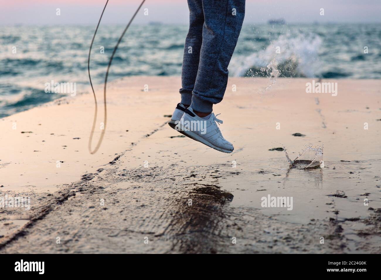 Close-up photo of jumping male in sportswear with skipping rope ...