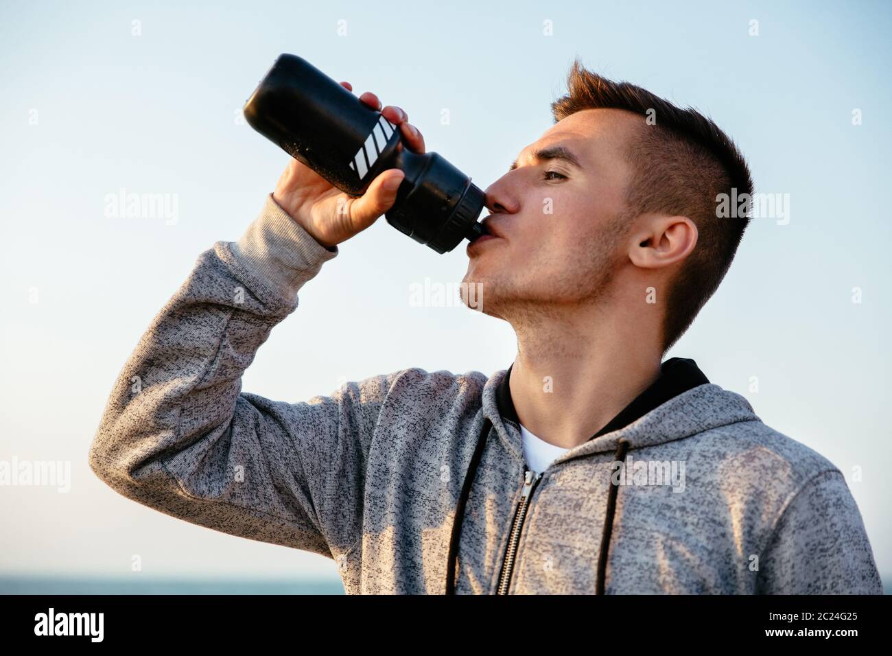 Handsome young sportsman standing drinking hi-res stock photography and ...