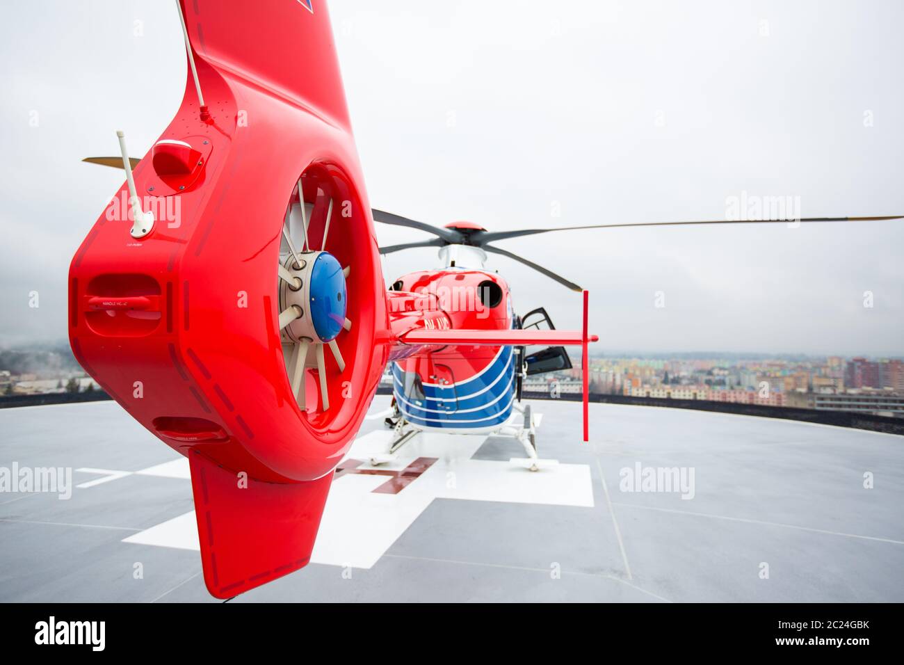 Modern medical helicopter on a hospital rooftop helipad from behind ...